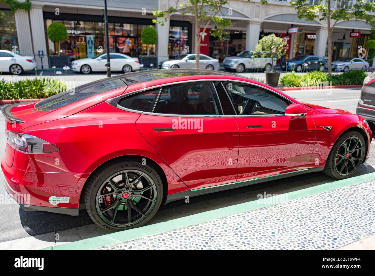 Side view of a bright red Tesla Model 3 automobile from Tesla Motors ...