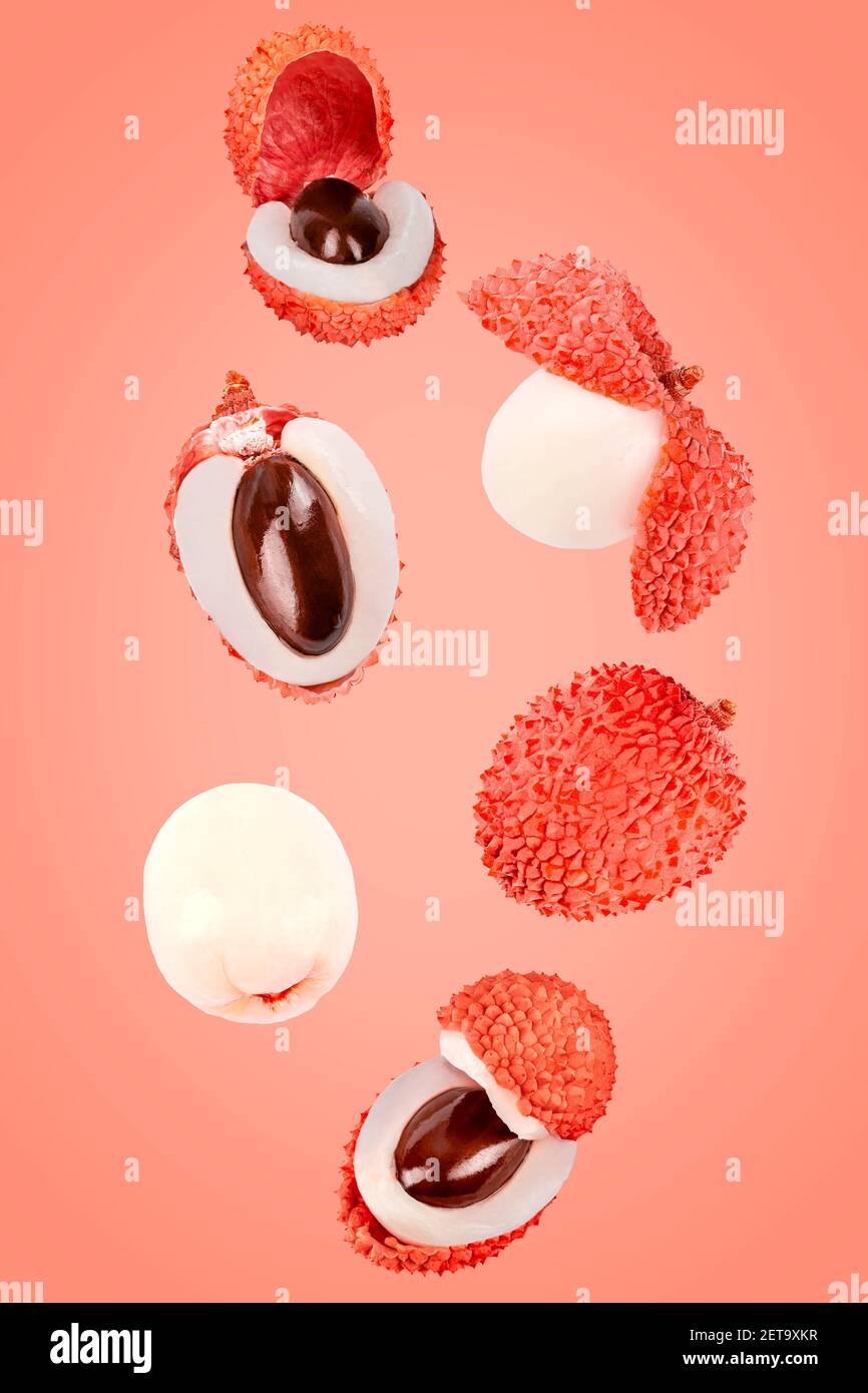 Flying fresh lychee fruits on coral colour background Stock Photo - Alamy