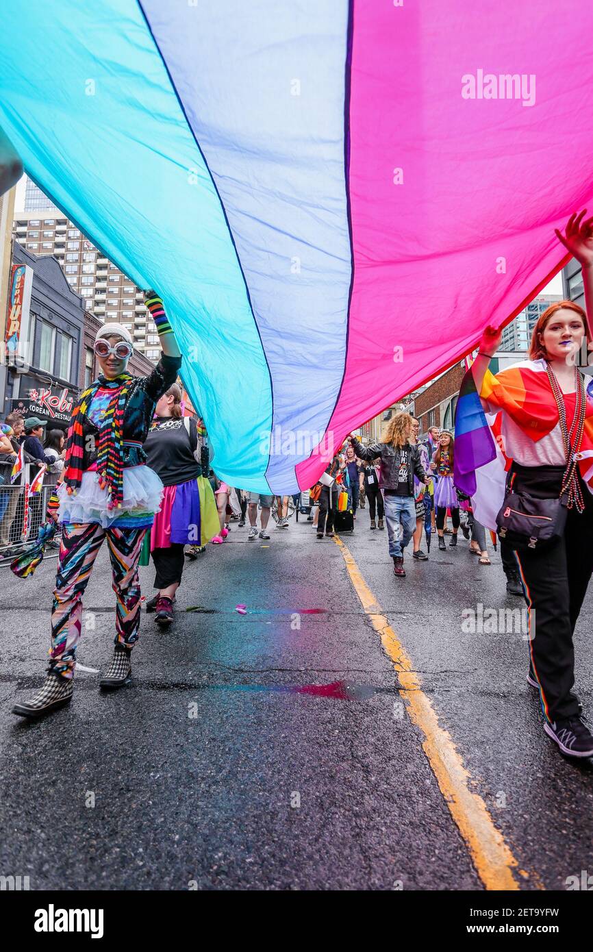 Participants marching with a huge rainbow flag during the Toronto LGBTQ ...