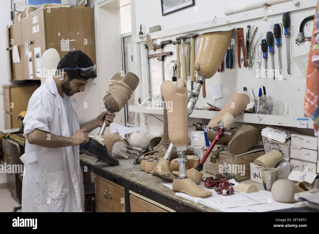 A Palestinian youth at a prosthetic center in Gaza repairs a limb for ...