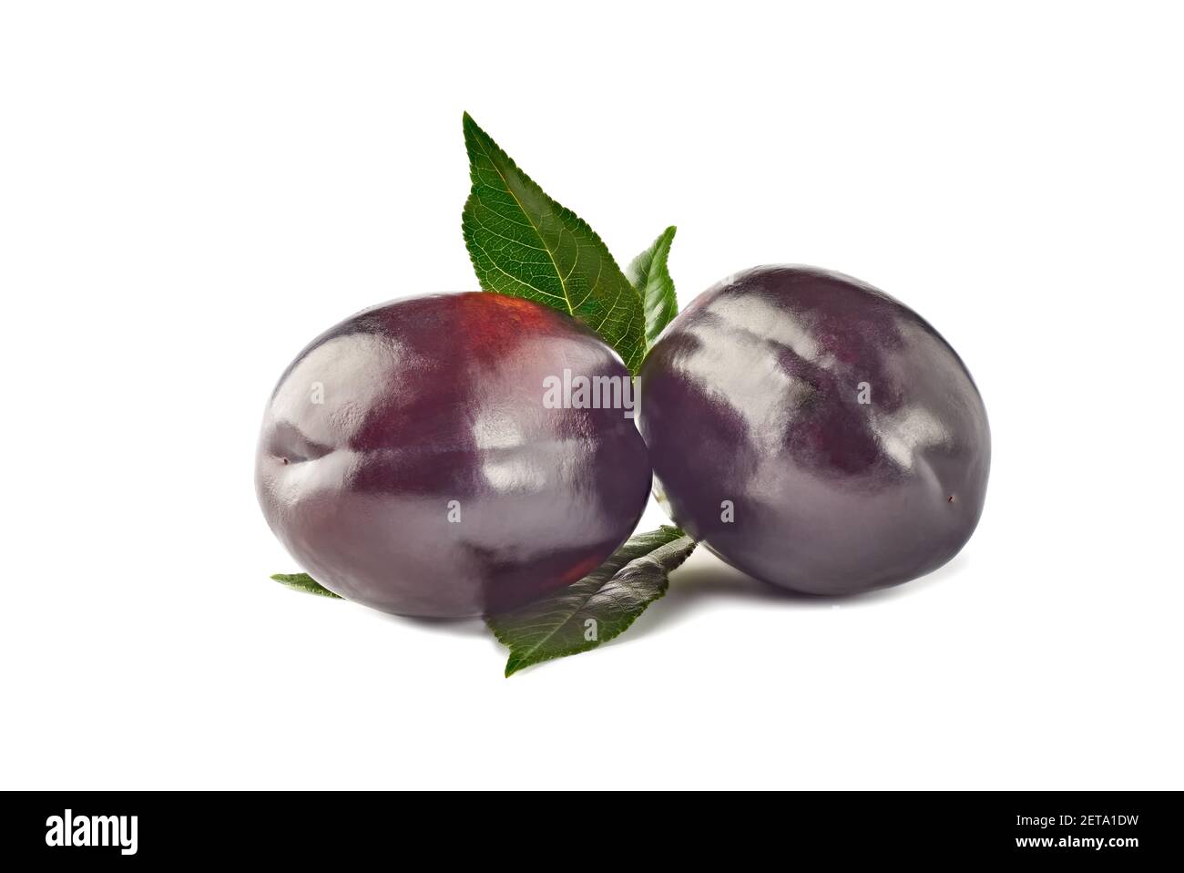 Two ripe plums with leaves on white Stock Photo - Alamy