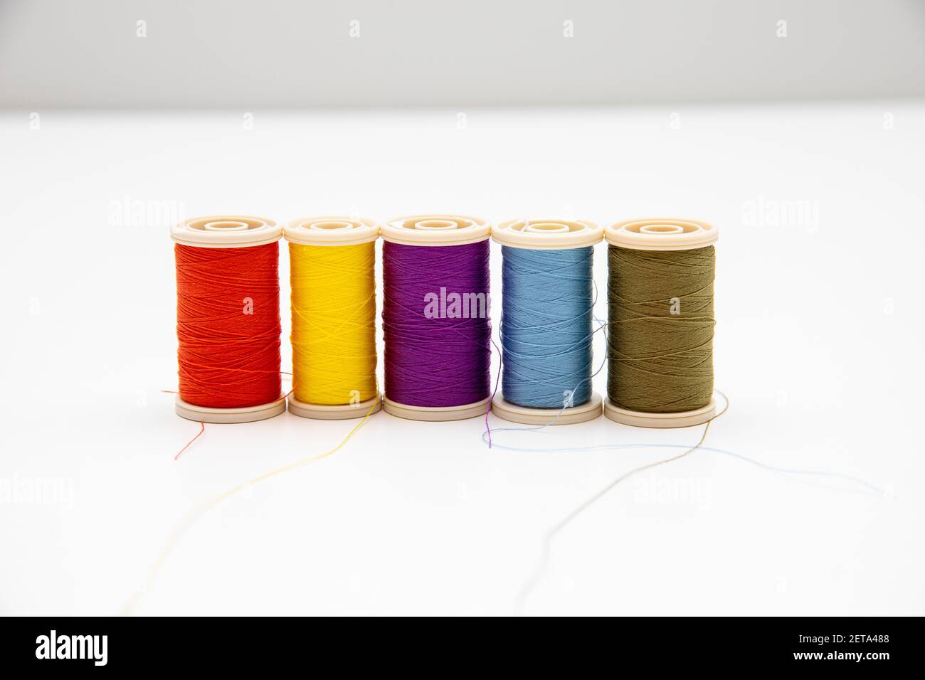 Five spools of colorful threads isolated in the light background Stock ...
