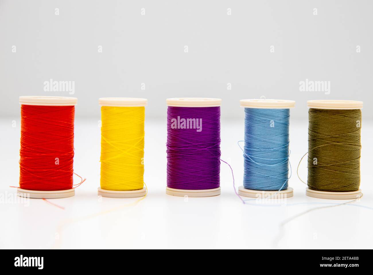 Five multi-colored thread spools isolated in the light background Stock ...