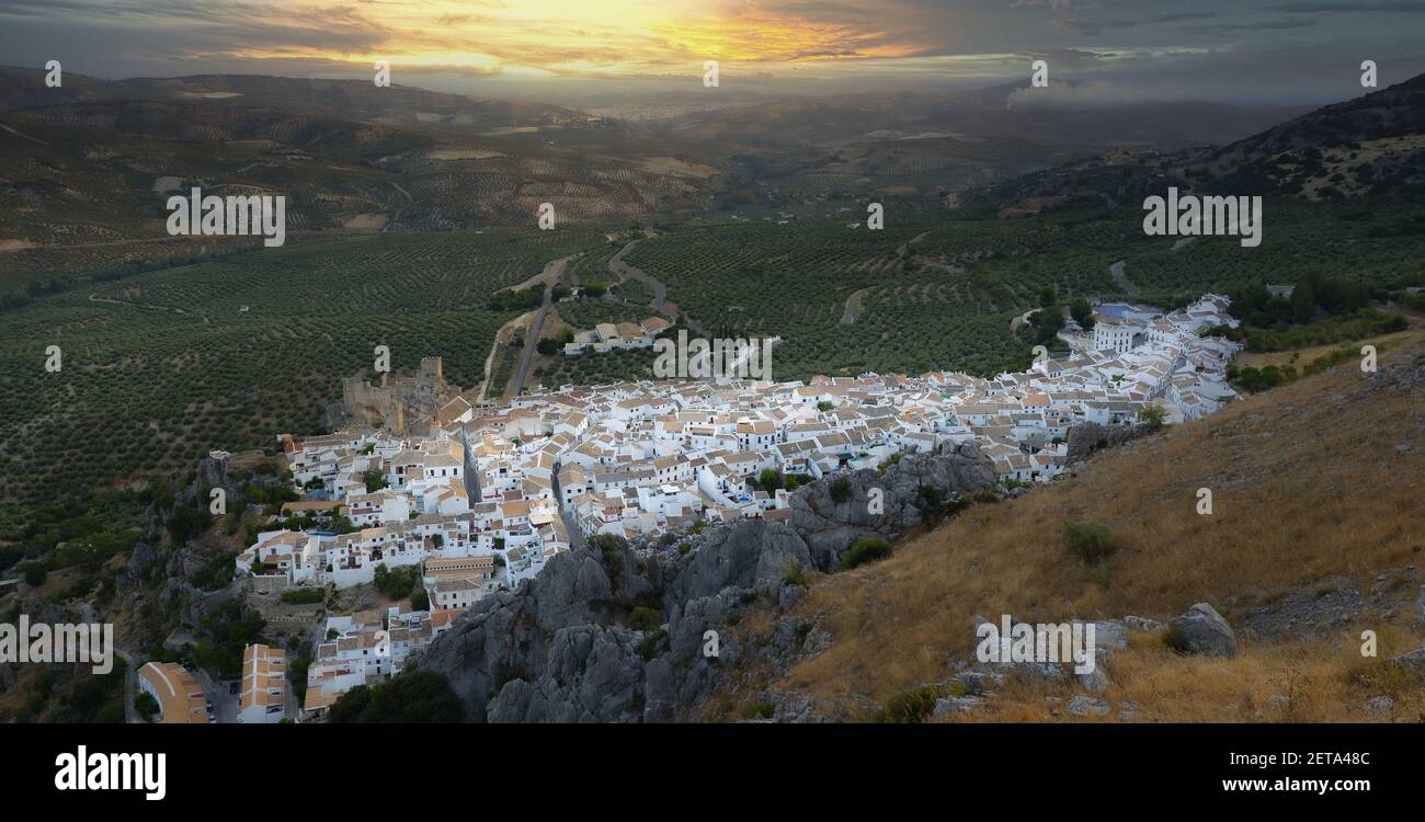 An aerial shot of a small town surrounded by hills and fields under ...