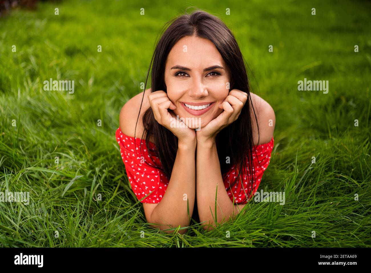 Full size photo of positive nice pretty woman lie grass hold hands ...