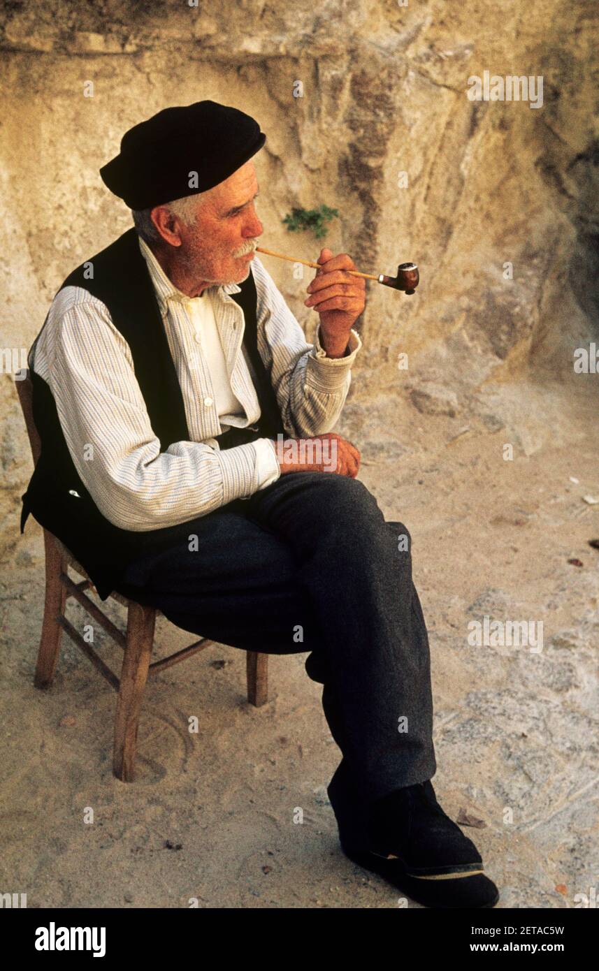 1970s SENIOR LOCAL CHARACTER MAN SITTING ON STOOL SMOKING A PIPE ...