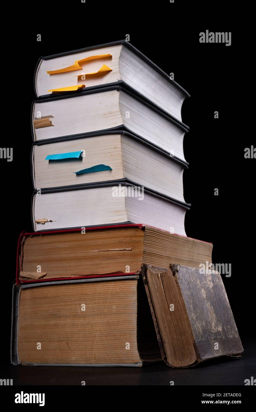 A stack of books on the desk. Old extensive literary publications. Dark ...