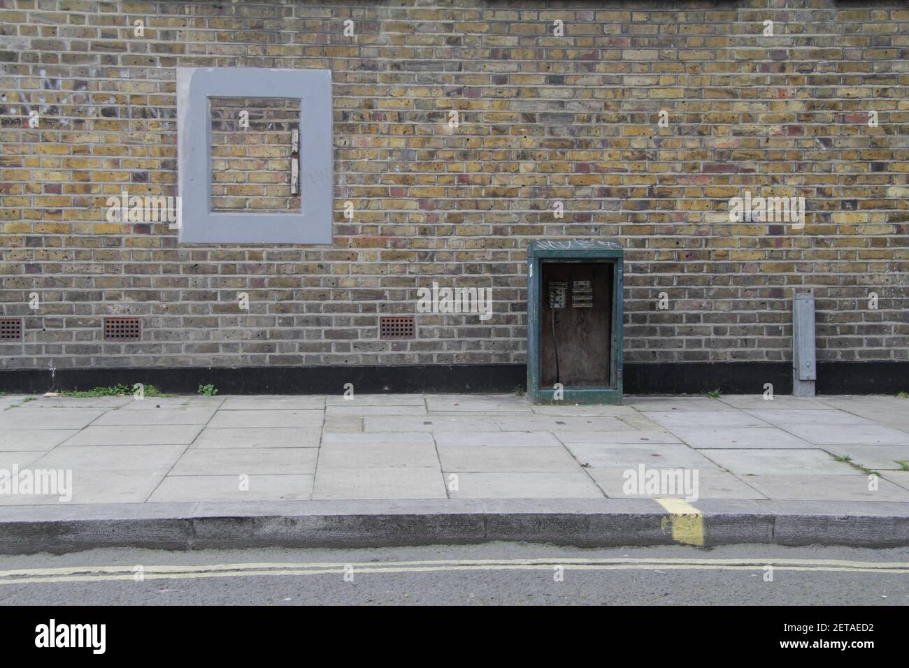 Open Electrical Box against Brick wall on pavement with Painted Square ...