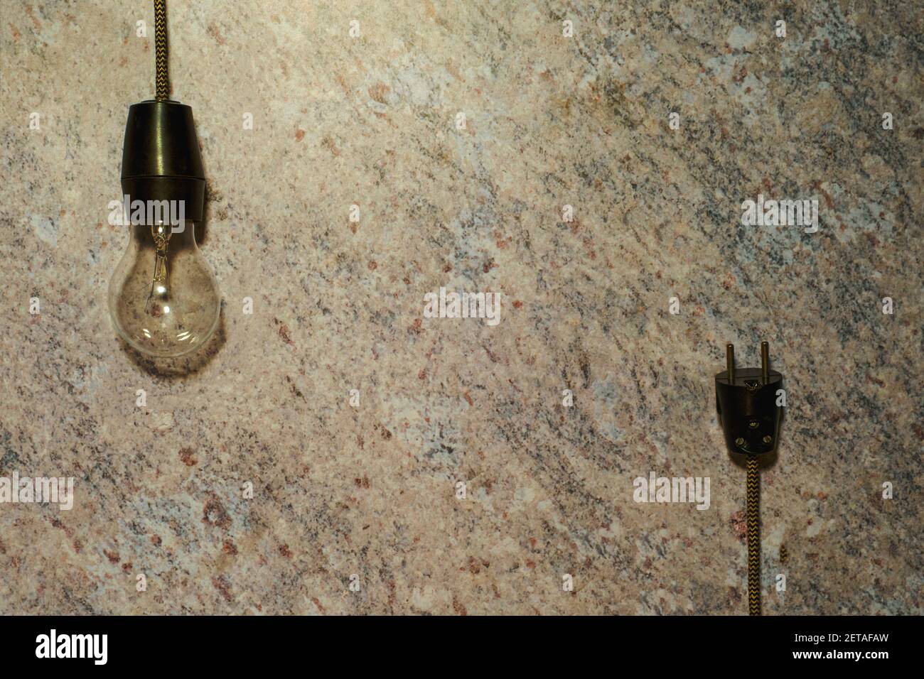 Frame formed by a vintage bulb hanging on a cable and its plug on a ...