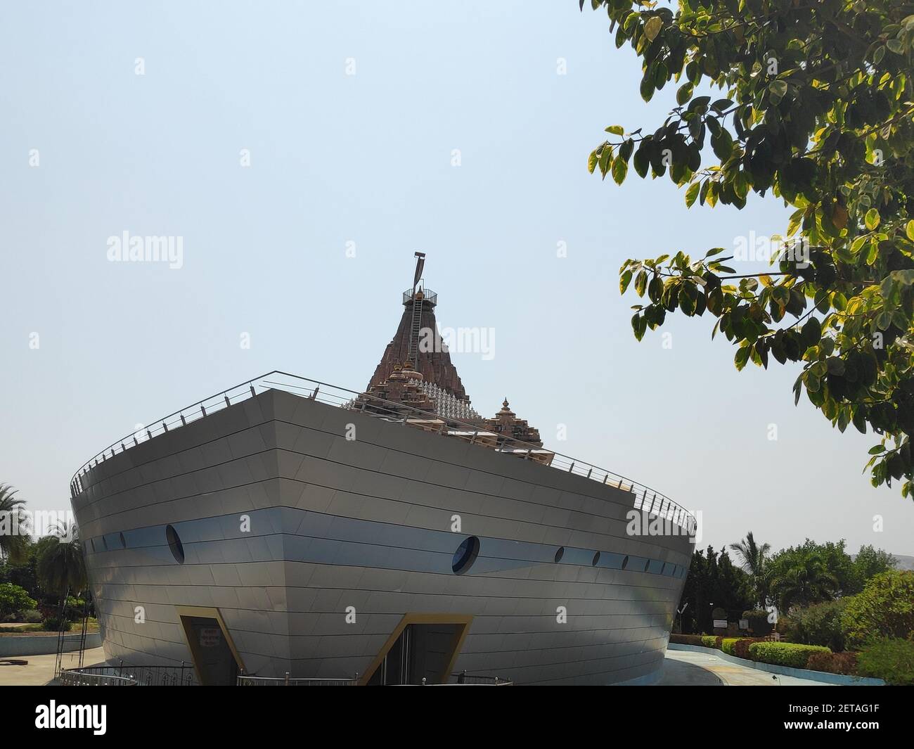 A beautiful ship-shaped building in a park with green trees under the ...