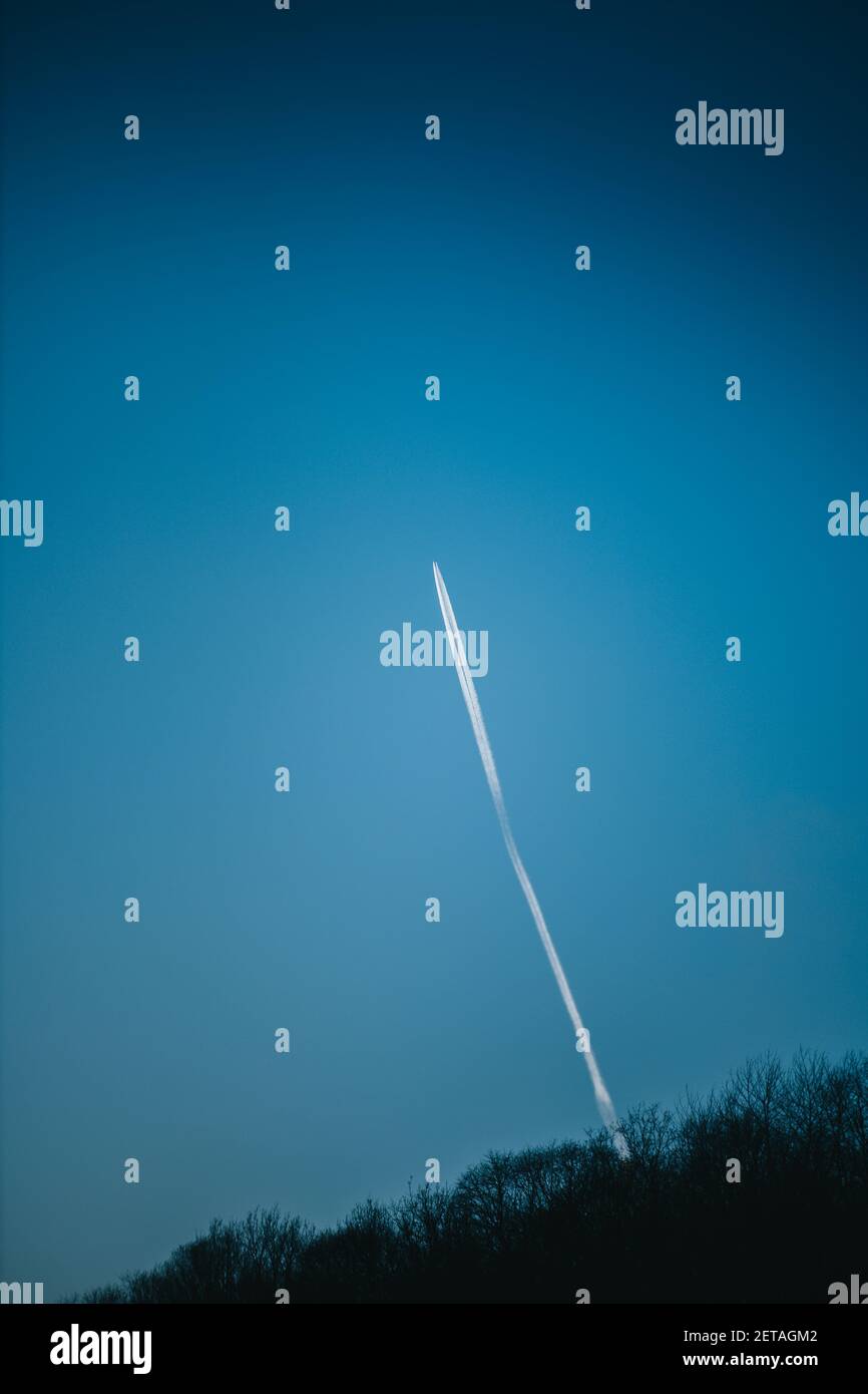 A beautiful shot of an airplane condensation trail going up on a blue ...