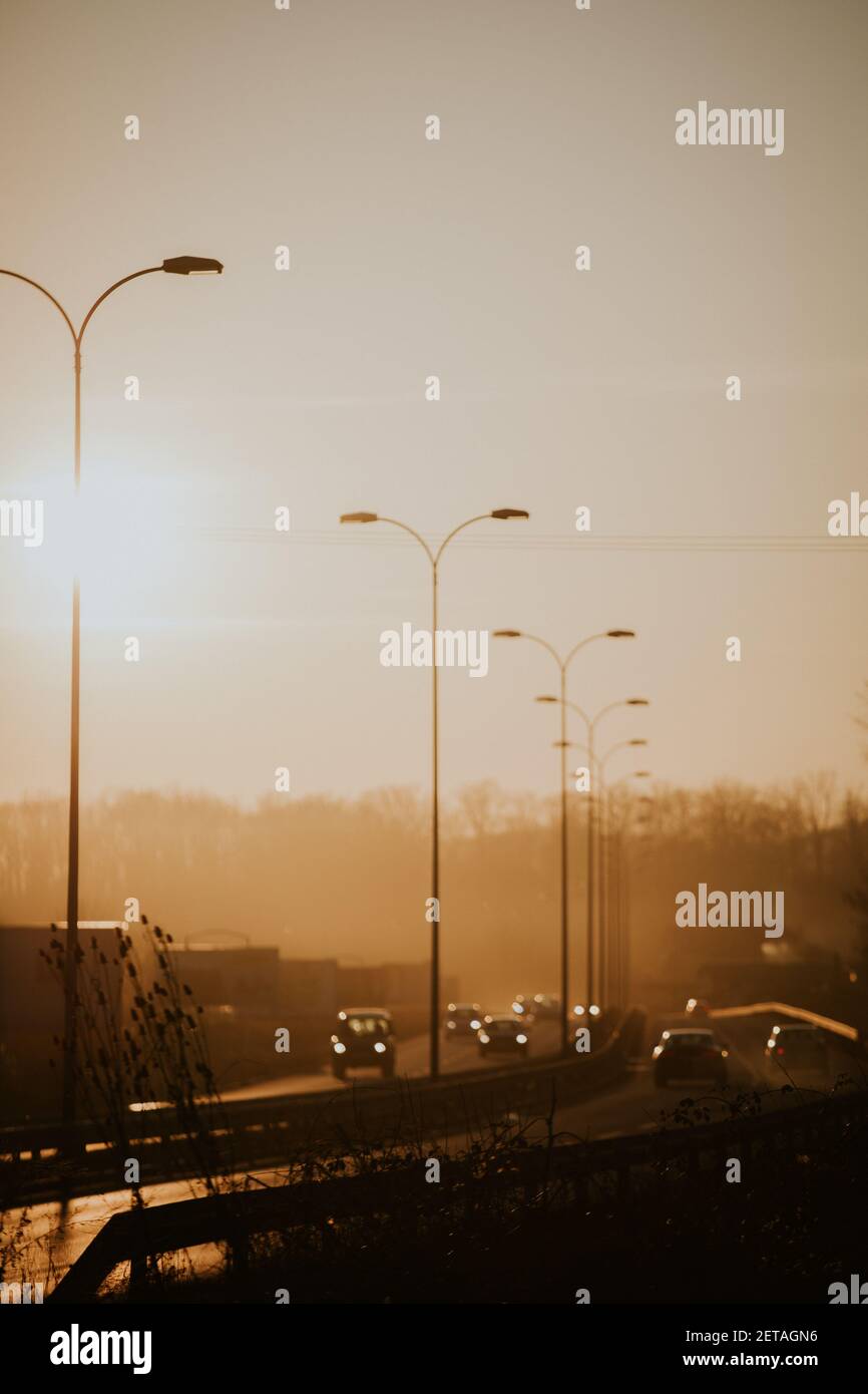 A vertical shot of street lights along the road at sunset Stock Photo ...