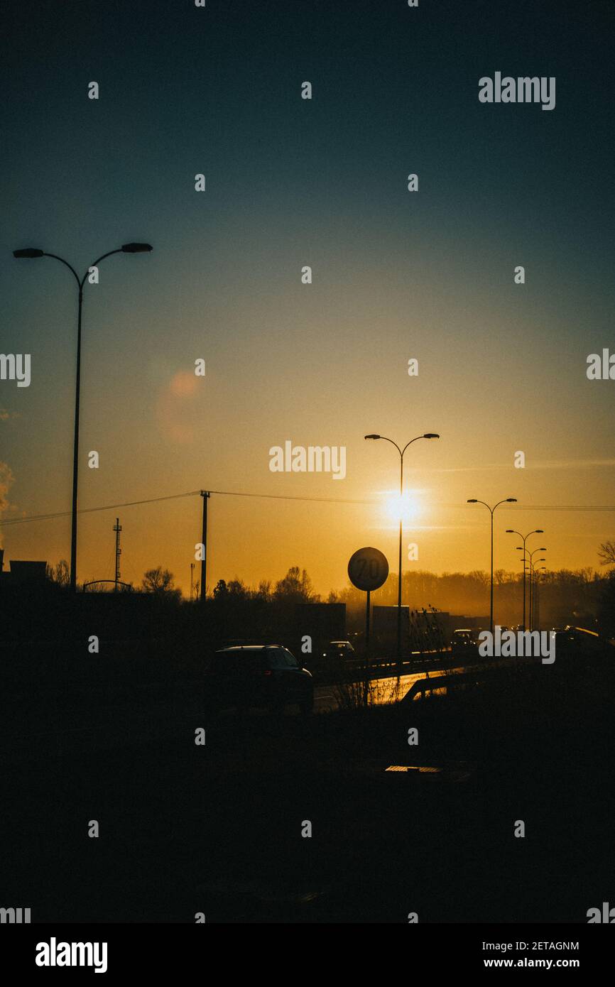 A beautiful shot of street lights along the road against a sunset sky ...