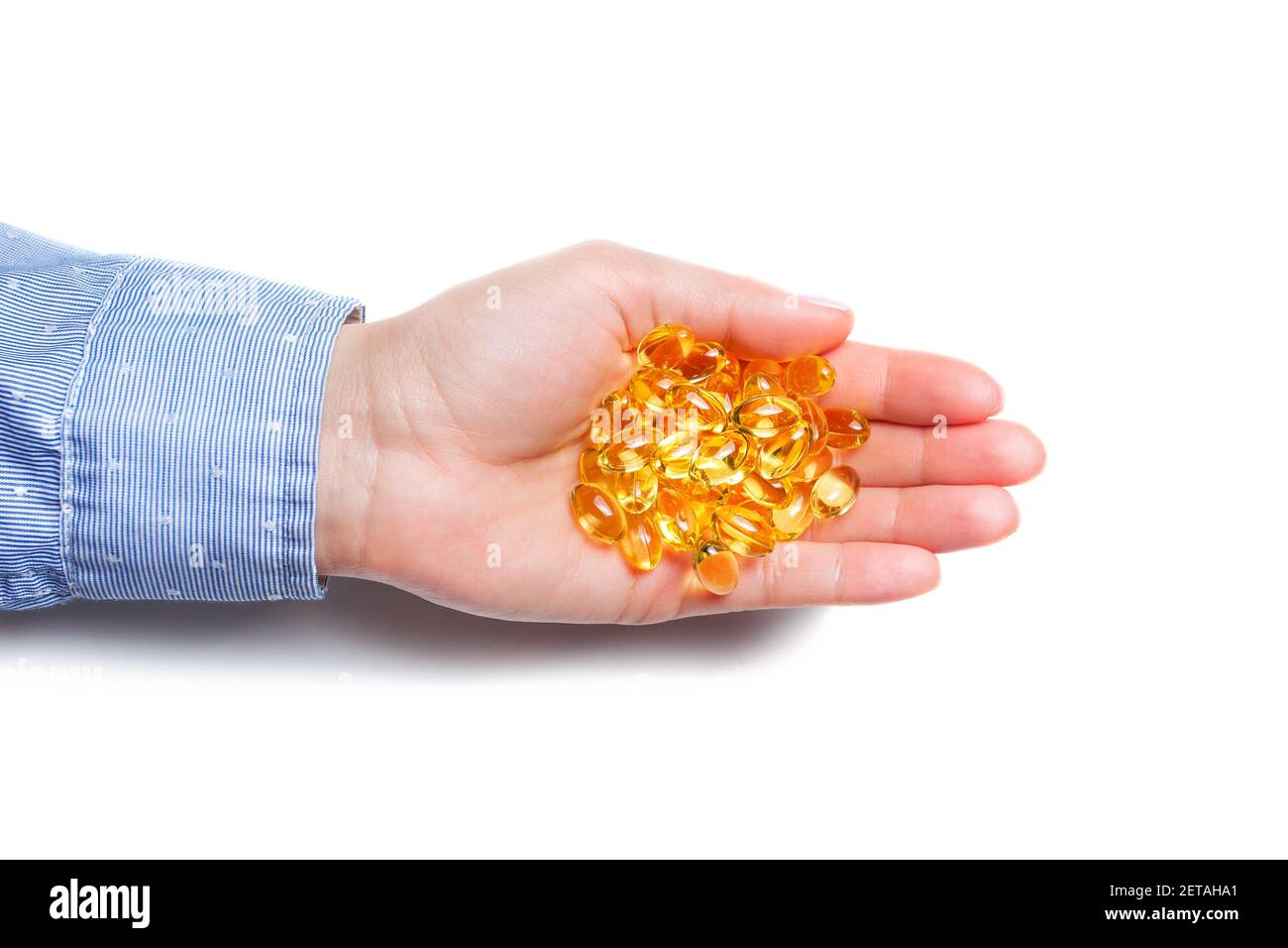 Hand holds omega-3 capsules isolated on white background. Fish oil ...