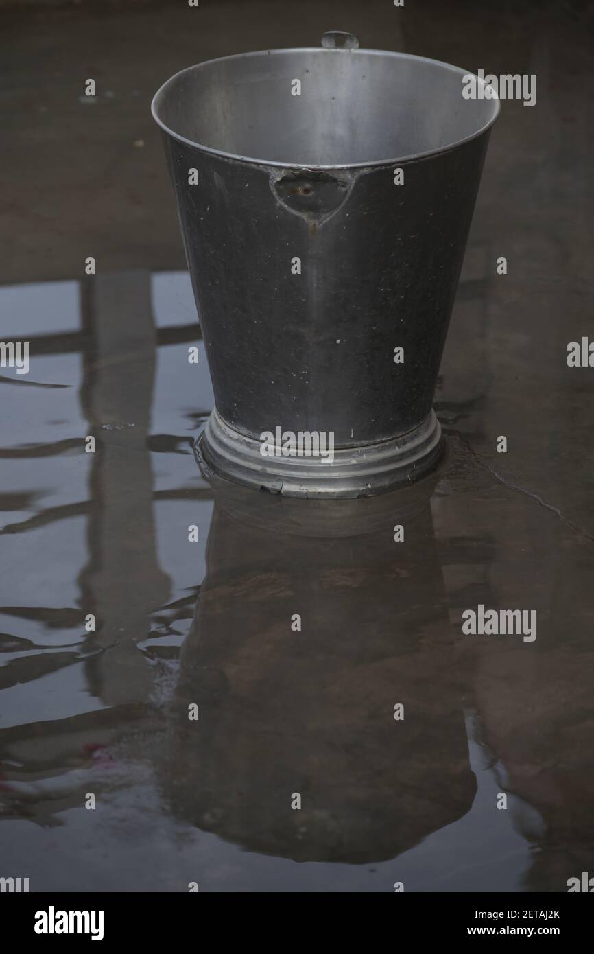 An old metal bucket on a wet surface Stock Photo - Alamy