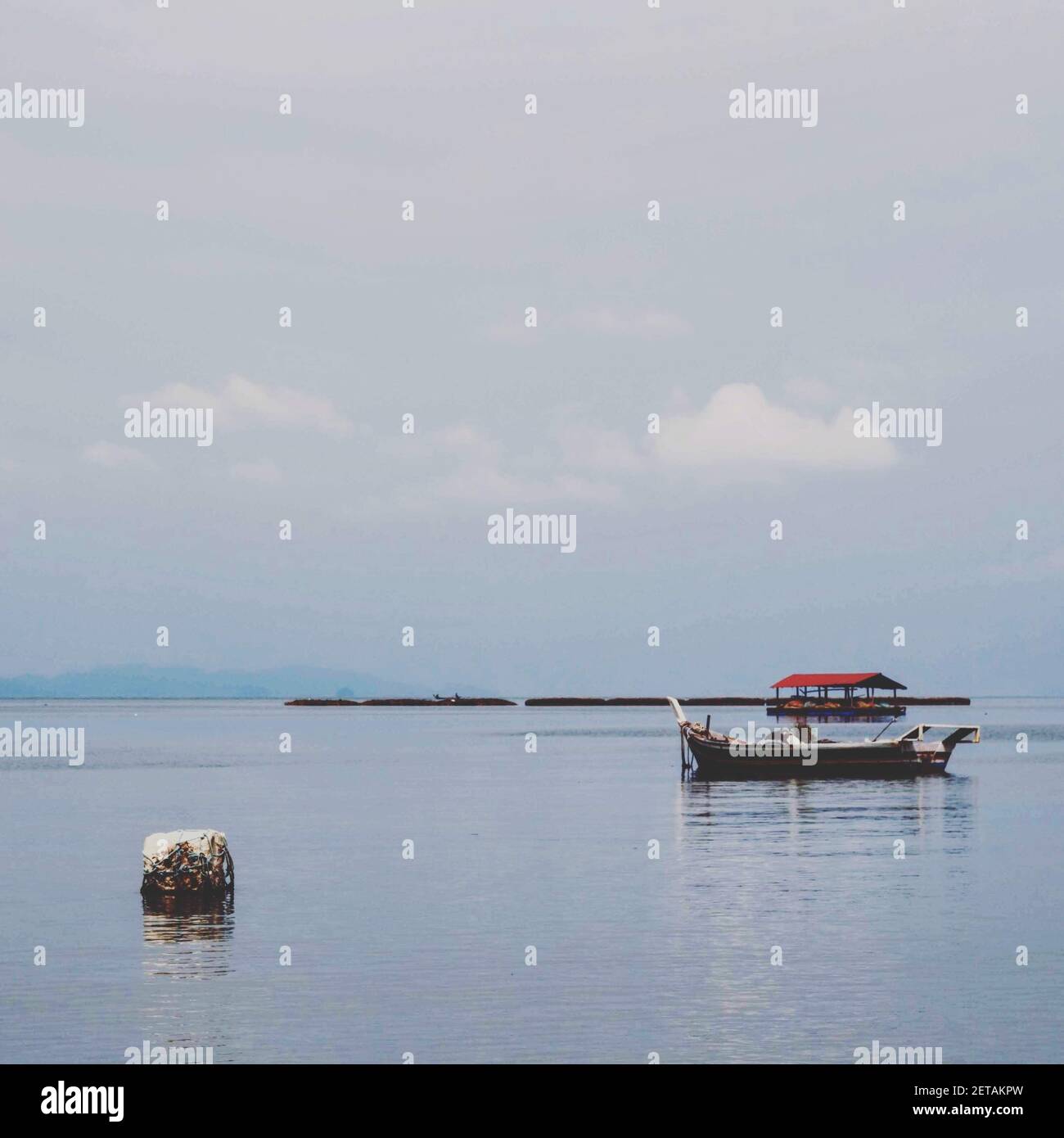 A beautiful scenery of a little fishing boat on a calm sea Stock Photo ...