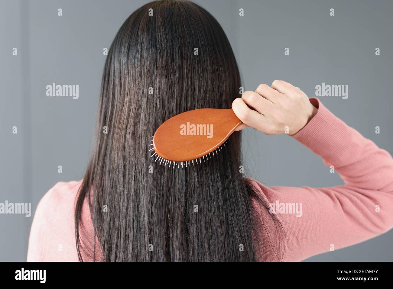 Brunette woman combs her hair with comb Stock Photo - Alamy