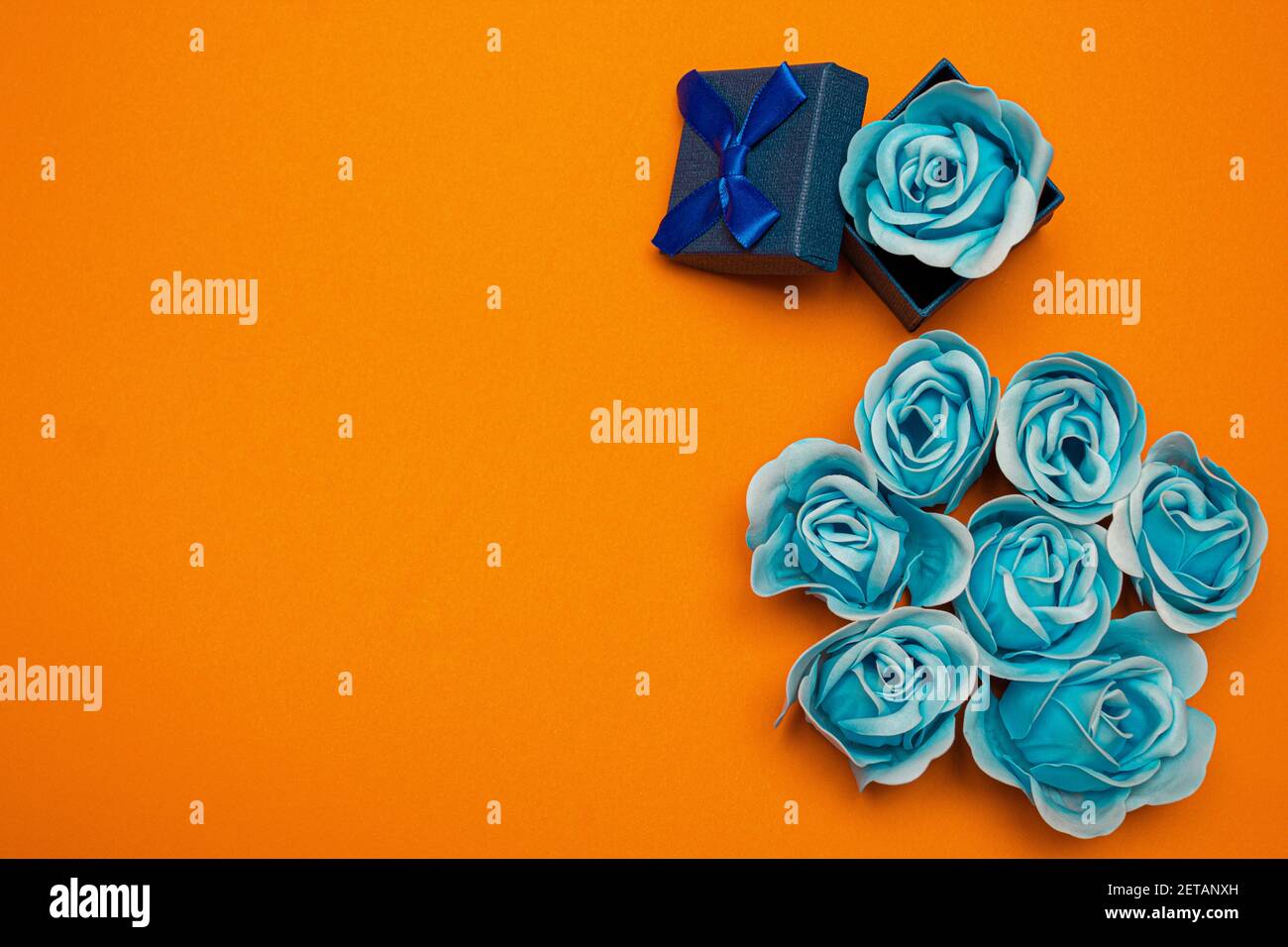 Blue rose flowers with a rose flower in a blue gift box on an orange ...
