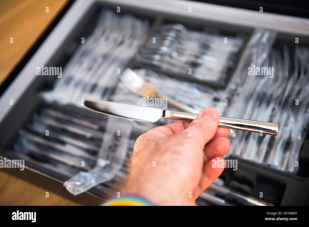 POV male hand holding new cutlery sets flatware inspecting the dinner ...
