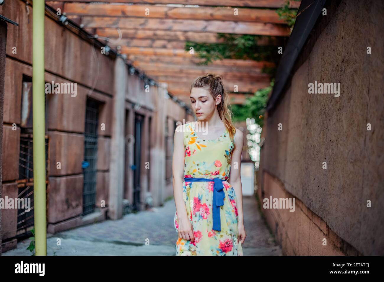 girl in dress walks through the old town in the summer. Beautiful ...