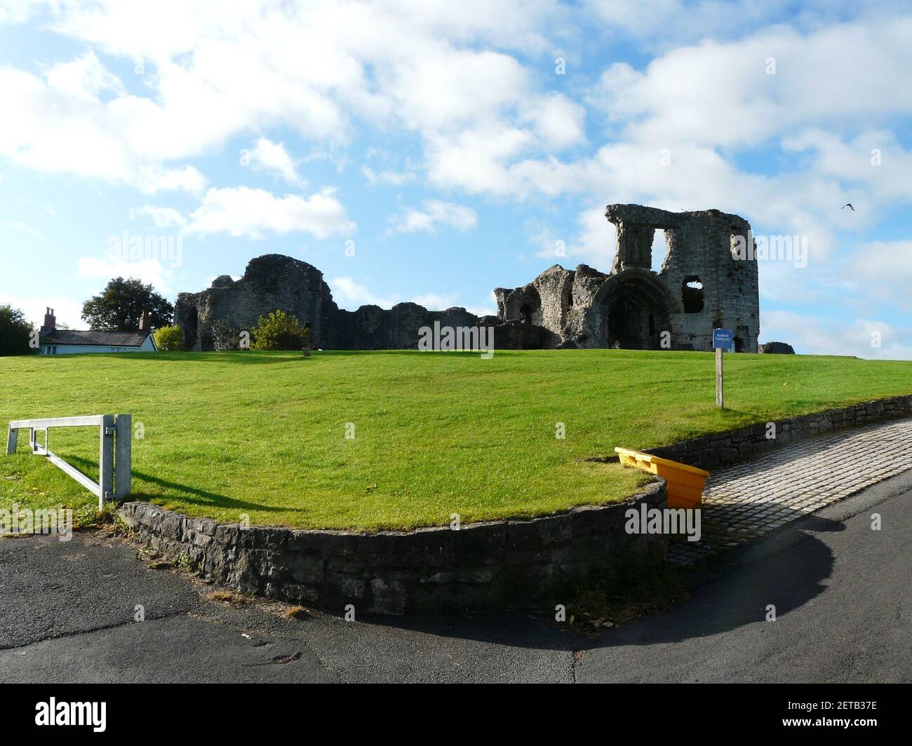A half-ruined facade of an old medieval castle under the clear sky in ...