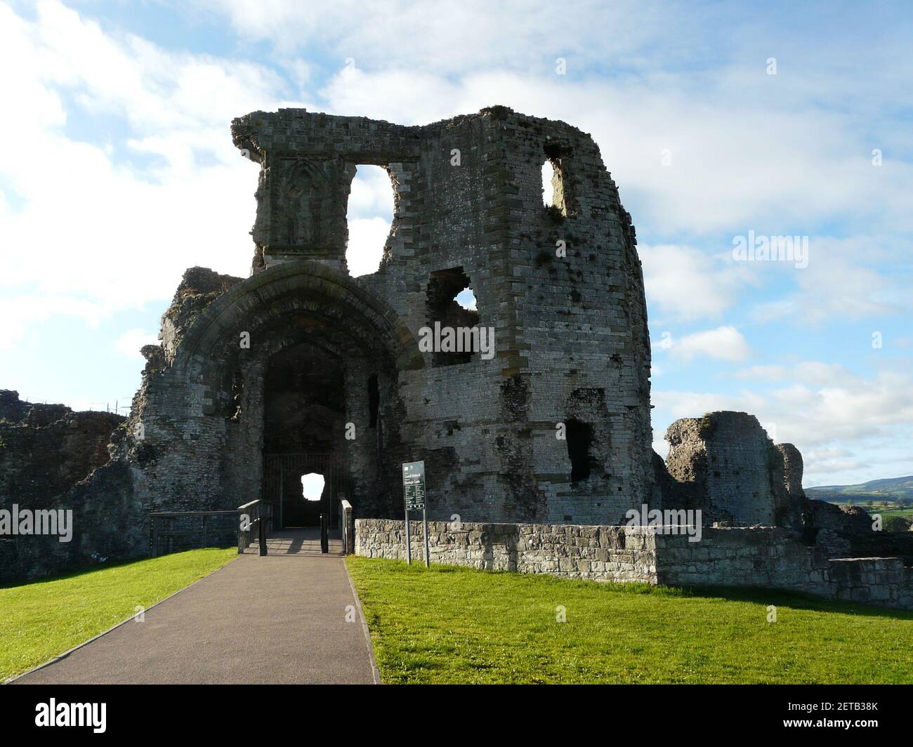 An old half-ruined facade of a medieval castle under the clear sky in ...