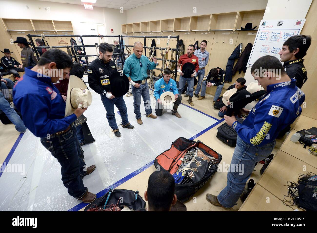 A group of professional riders pray together in their dressing room ...