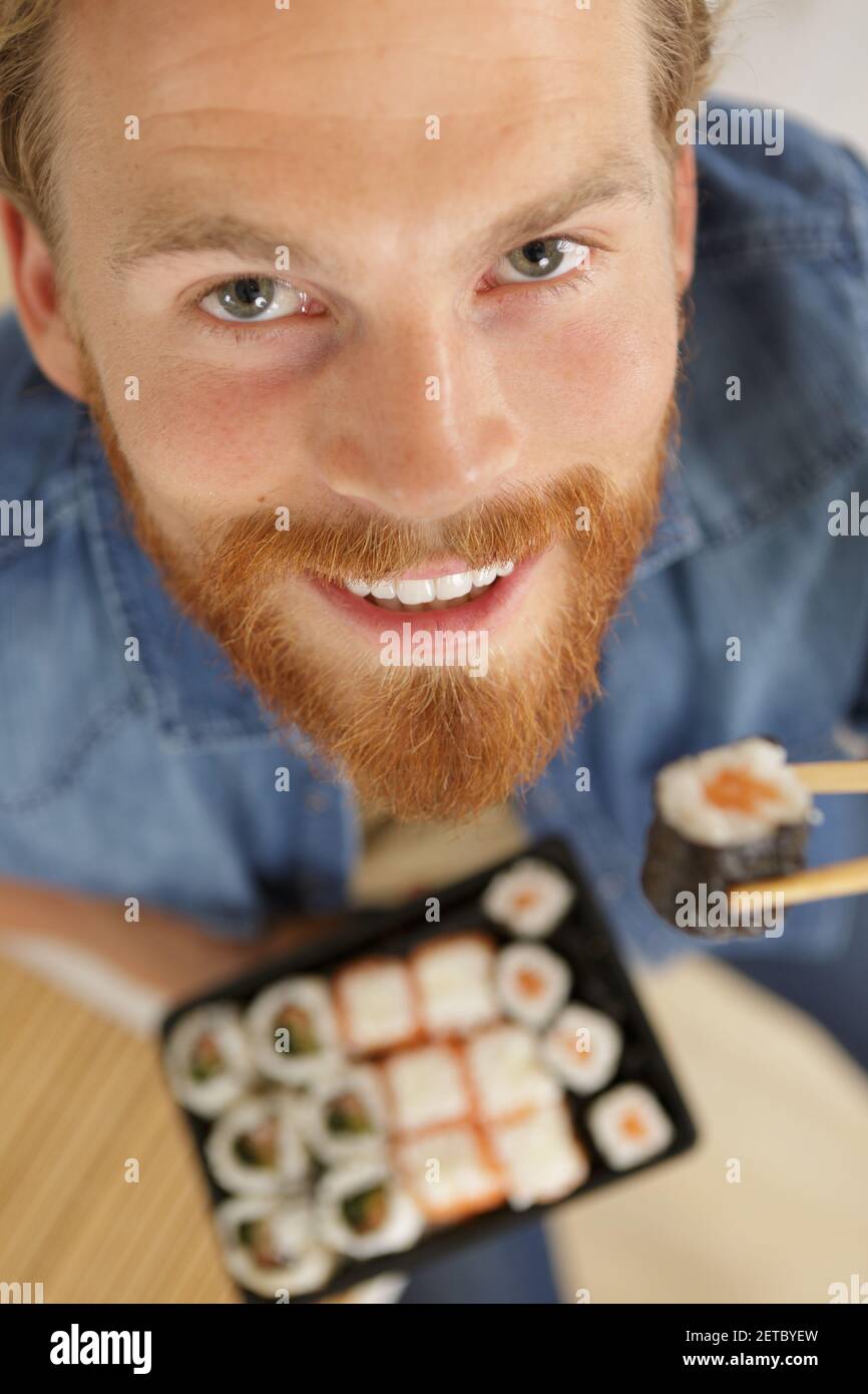 young man eating sushi roll Stock Photo - Alamy