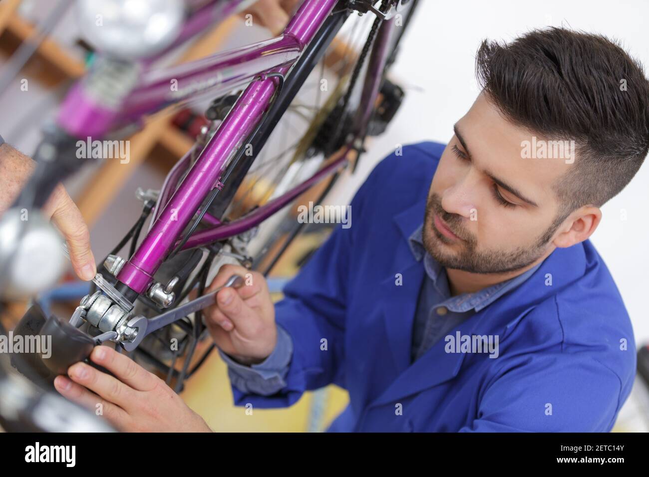 Mechanic using spanner on bicycle Stock Photo - Alamy
