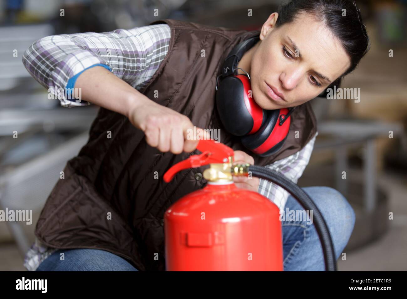 a woman using a fire extinguisher Stock Photo - Alamy