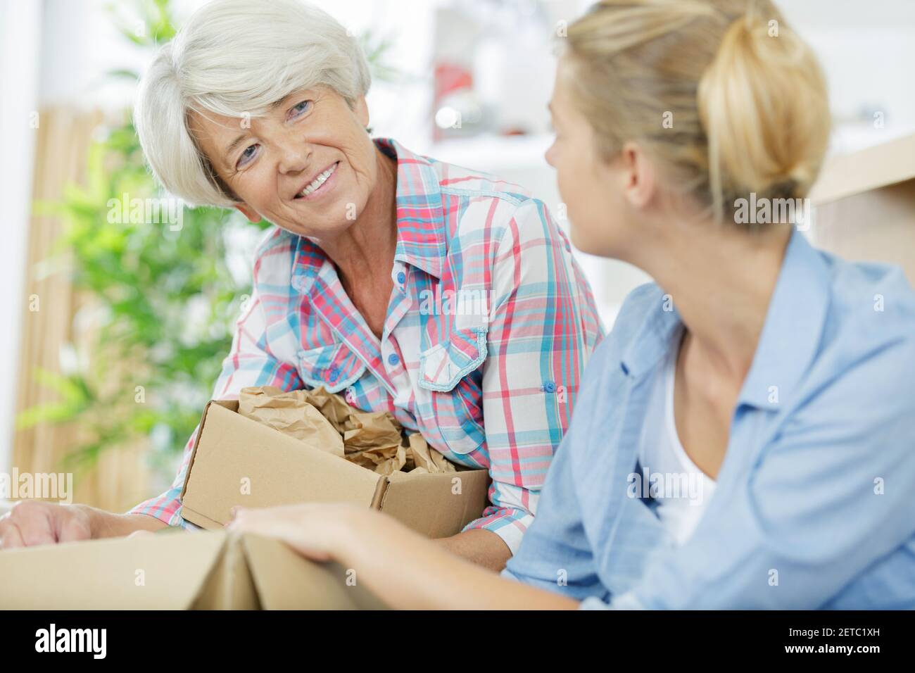 senior mum and daughter opening a box Stock Photo - Alamy