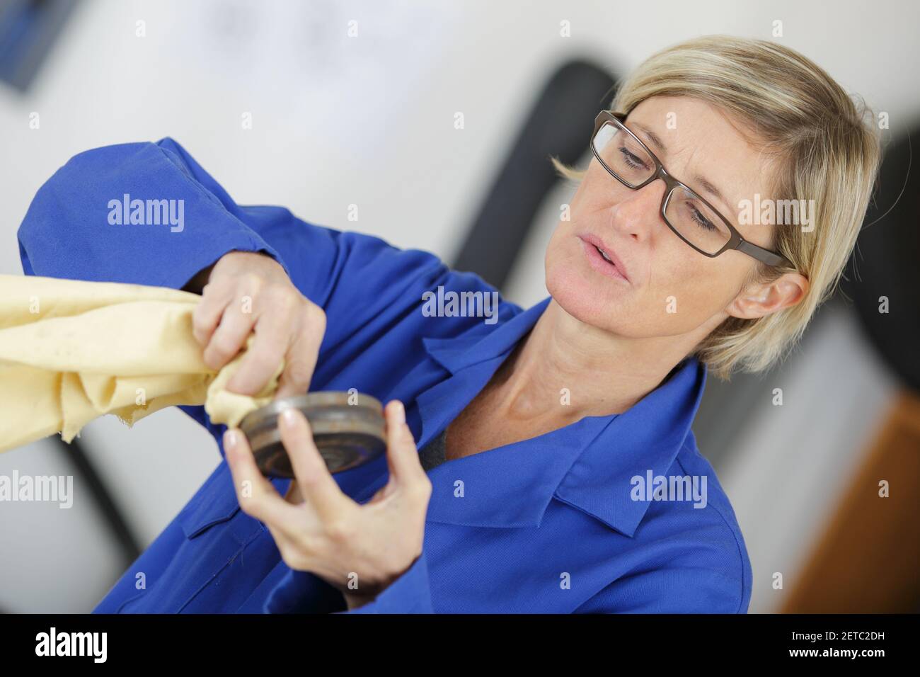 female engineer wiping inside of metal component with cloth Stock Photo ...