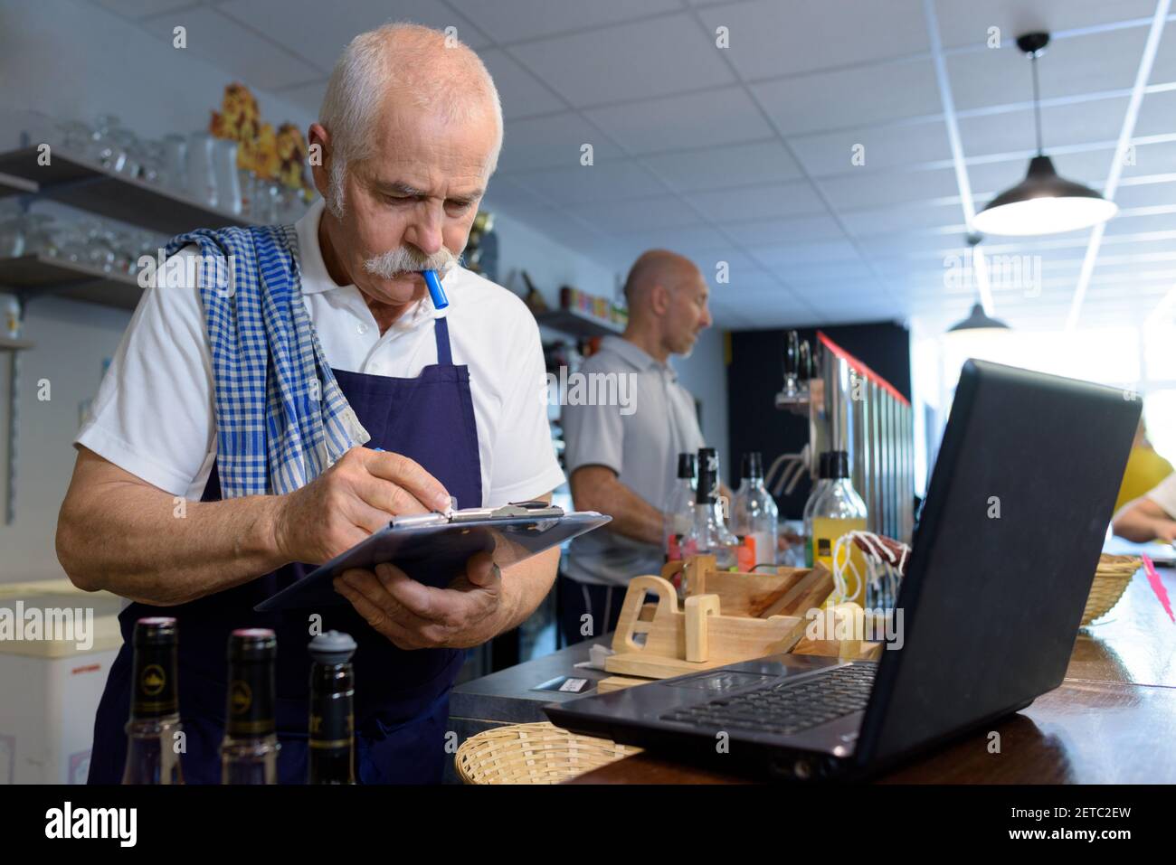 bartender checking paper on clipboard Stock Photo - Alamy