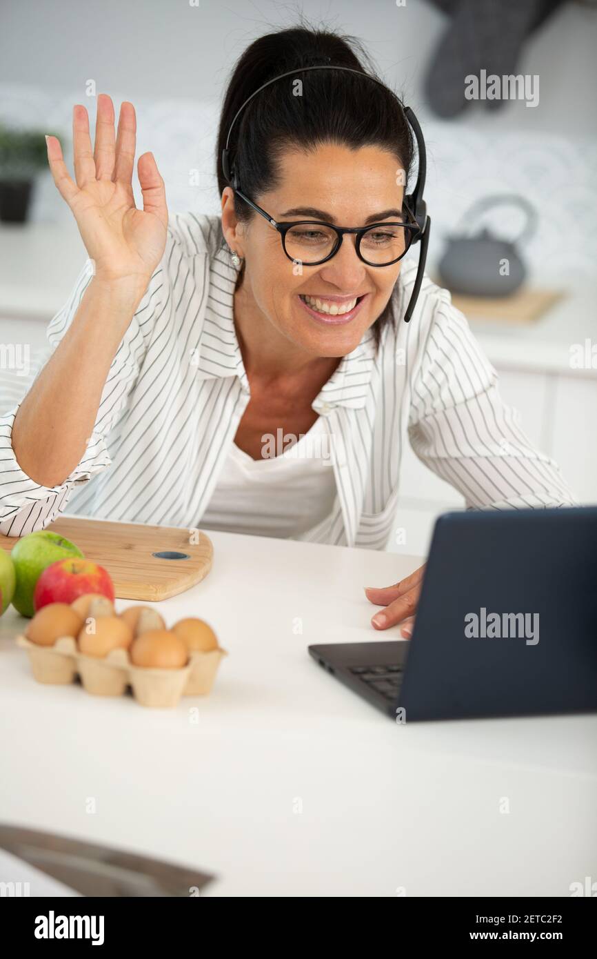 woman waving at screen while cooking Stock Photo - Alamy woman waving at screen while cooking Stock Photo - Alamy