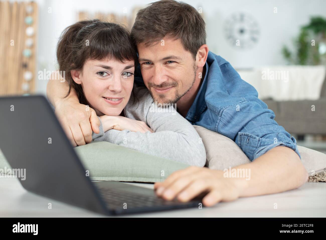 young happy couple hugging and using pc Stock Photo - Alamy