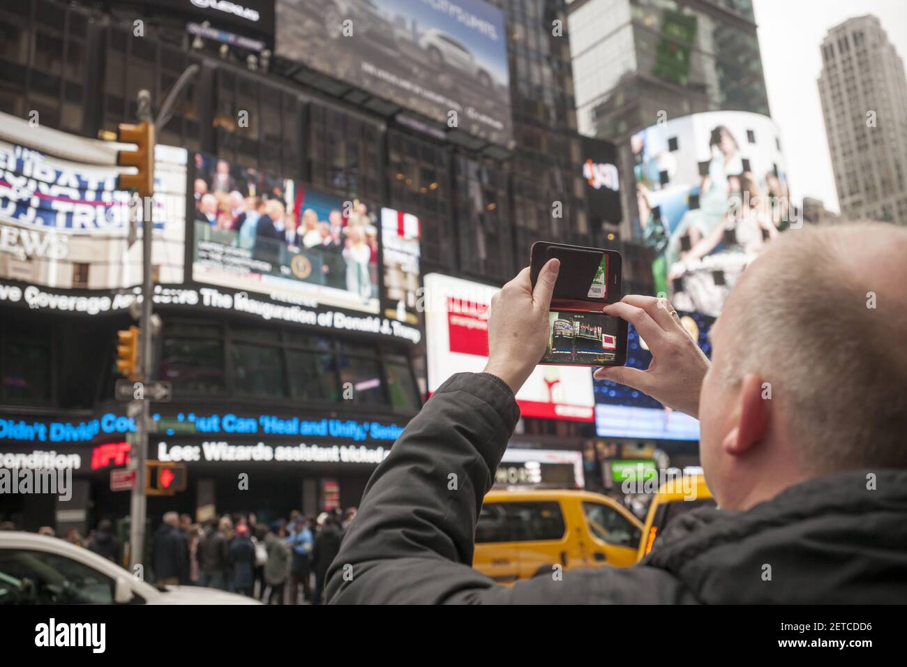 Visitors to Times Square in New York view the inauguration of Donald ...