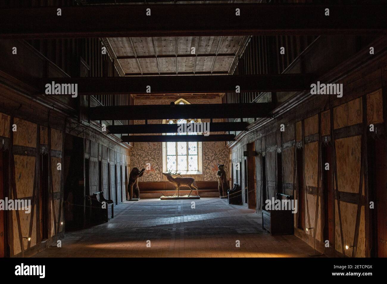A medieval building interior with animal sculptures next to the window ...