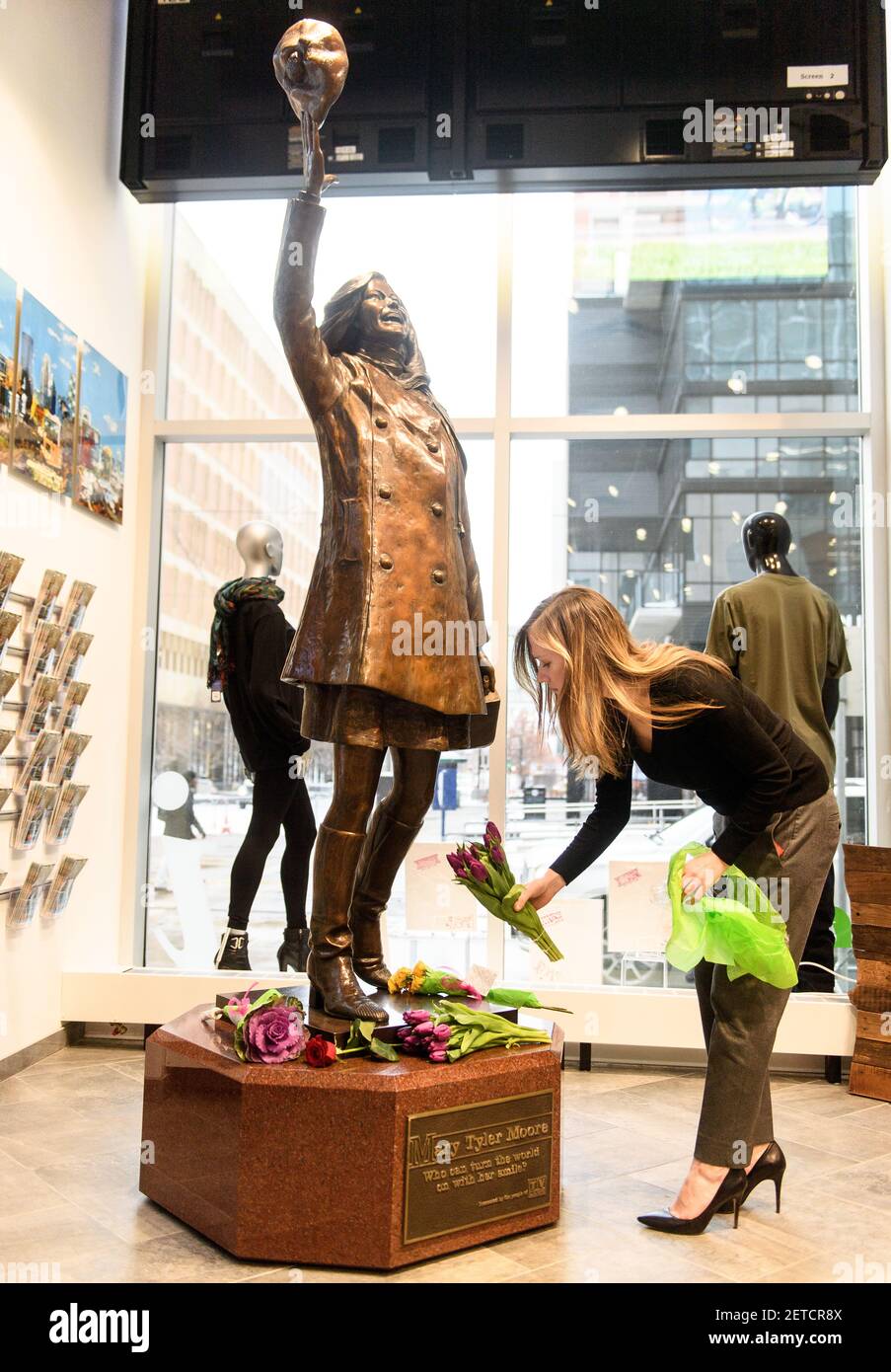 Alyssa Leary of Minneapolis places flowers at the base of Mary Tyler ...