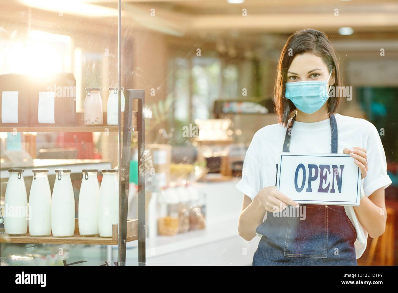 Shop owner showing open sign Stock Photo - Alamy