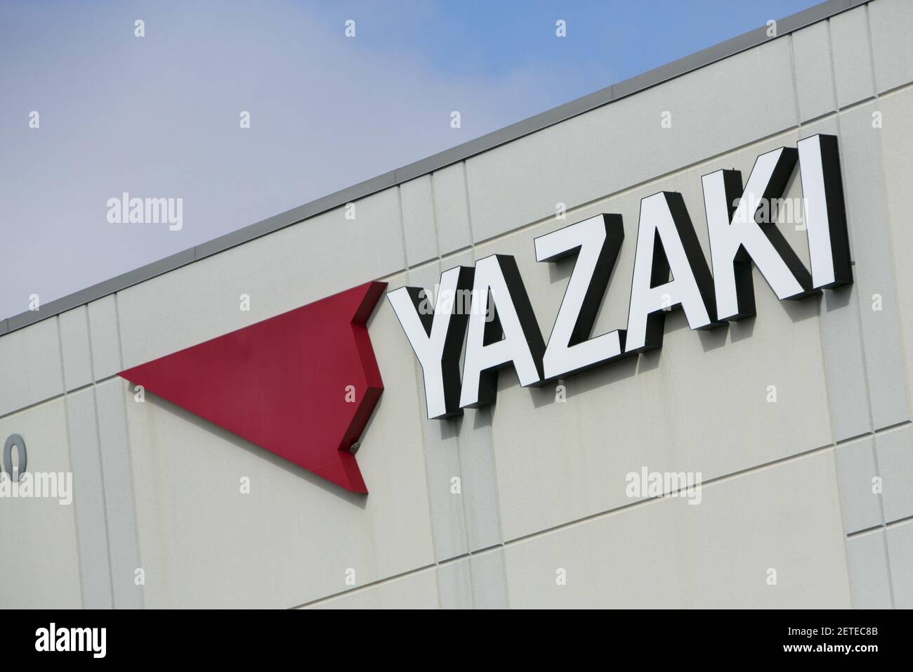 A logo sign outside of a facility occupied by the Yazaki Corporation in ...