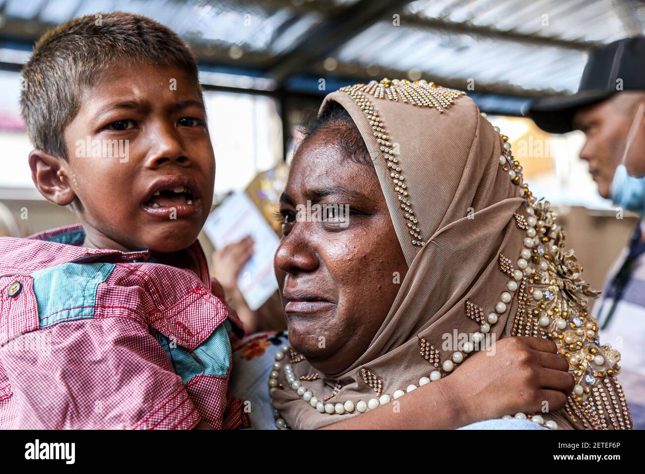 A woman and a child are seen crying at the funeral of Daw Dasi who was ...