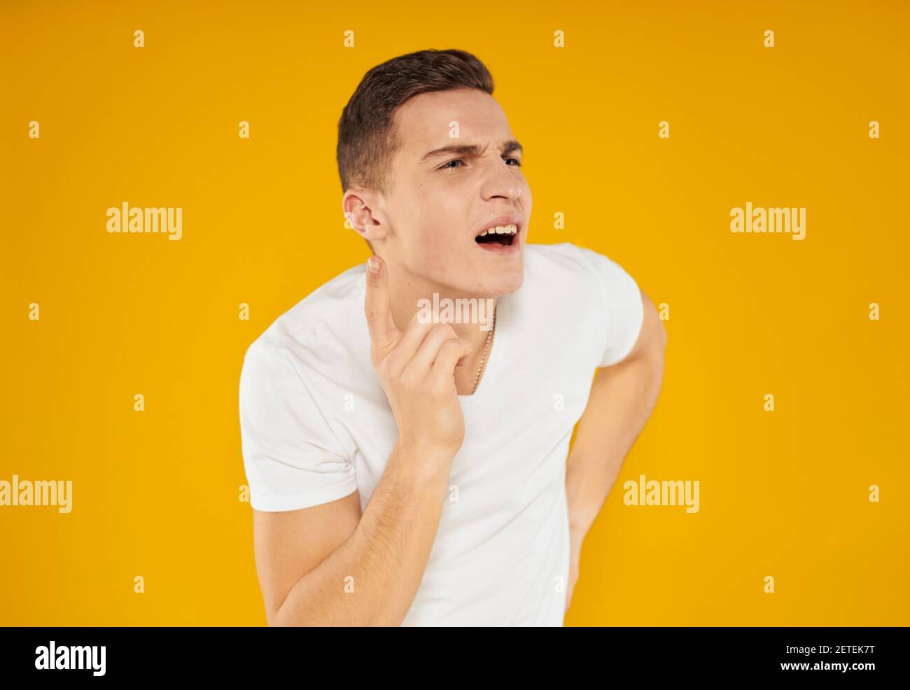 Emotional guy gesturing with his hands near his face on a yellow ...