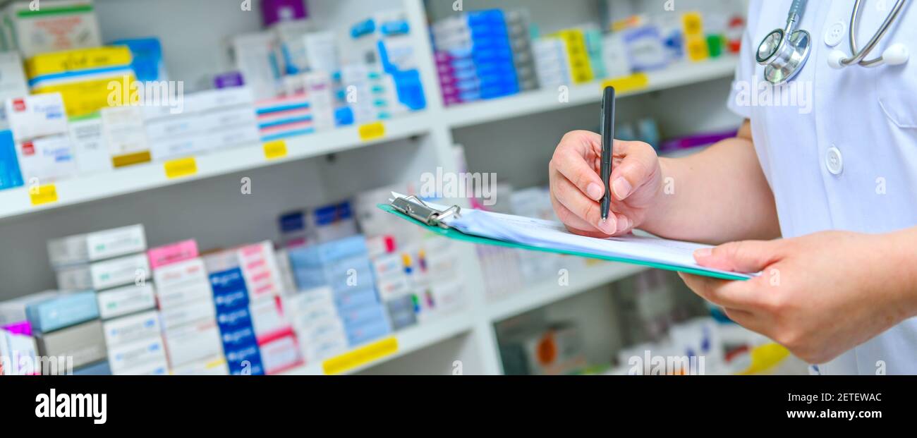 Doctor writing prescription with many medicine on shelves background ...
