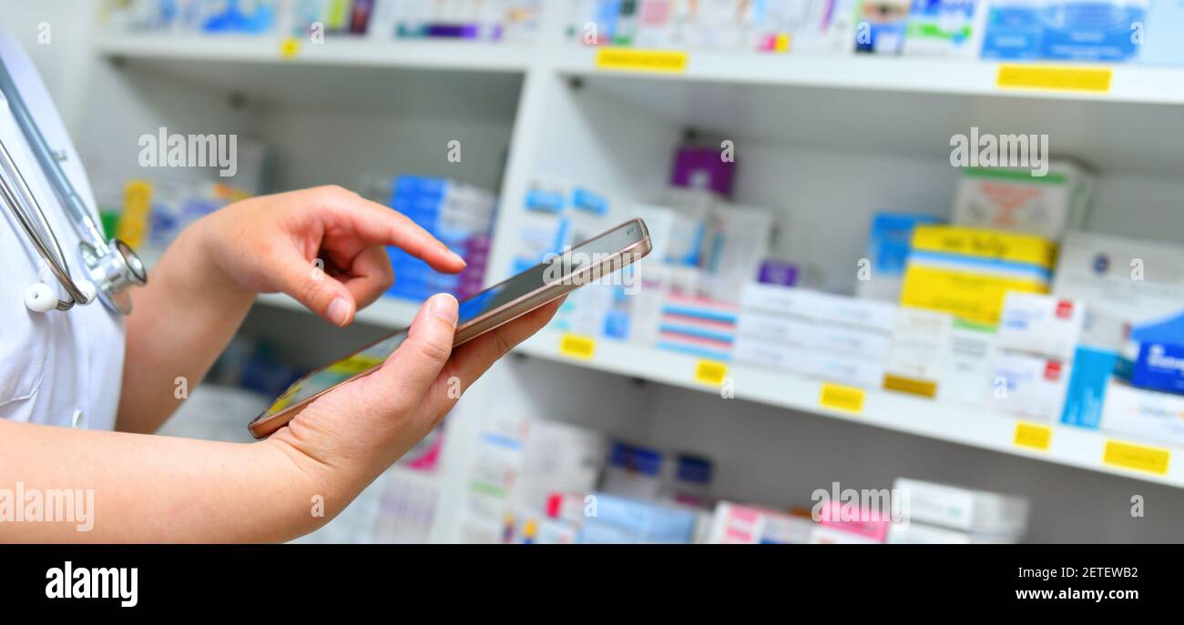 Pharmacist using mobile smart phone for search bar on display in ...