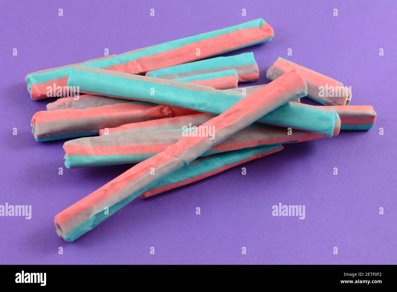 Strawberry milkshake chew candy sticks on purple background Stock Photo ...