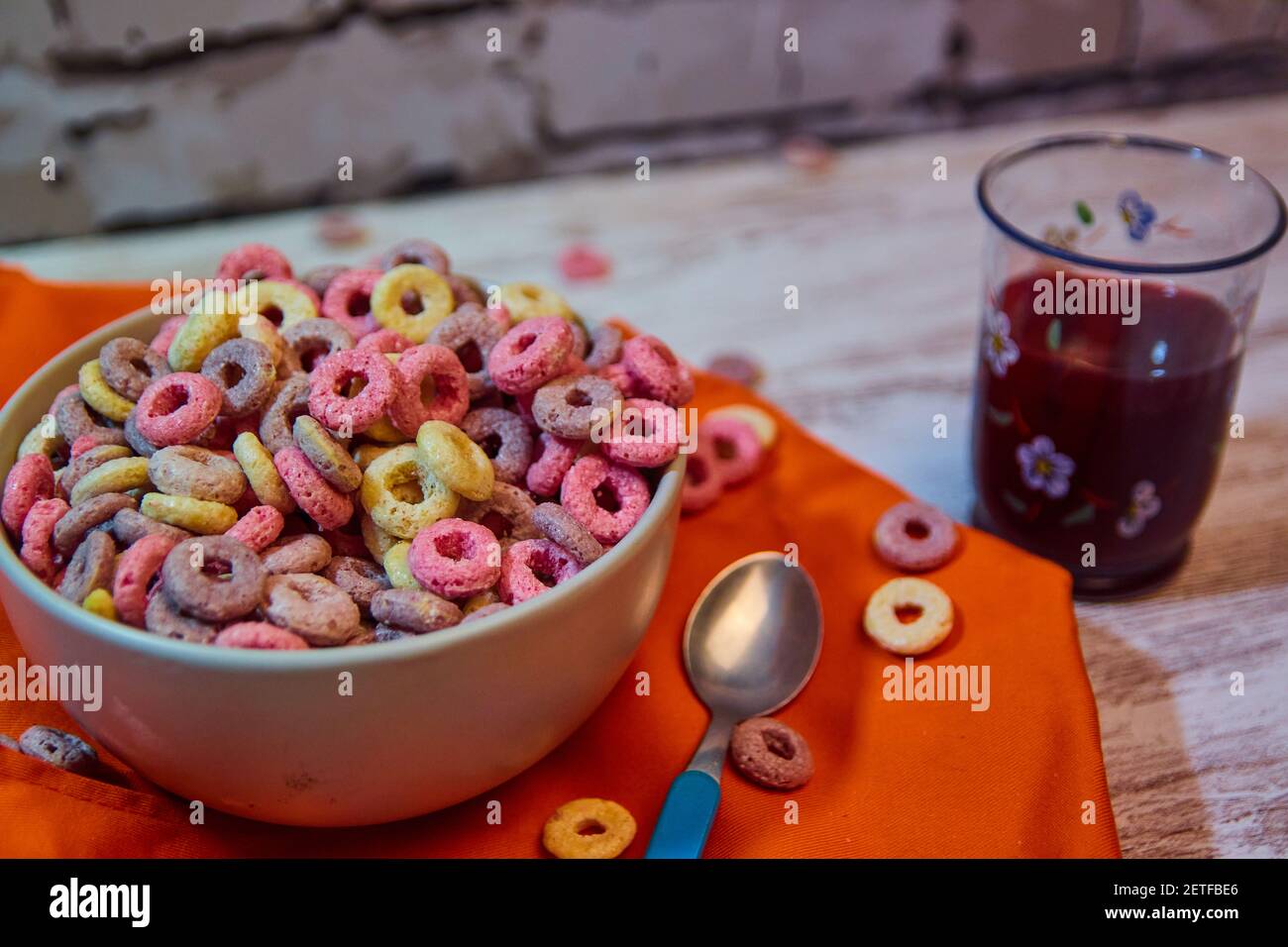bad breakfast of colorful cereals full of sugar with red fruit juice ...