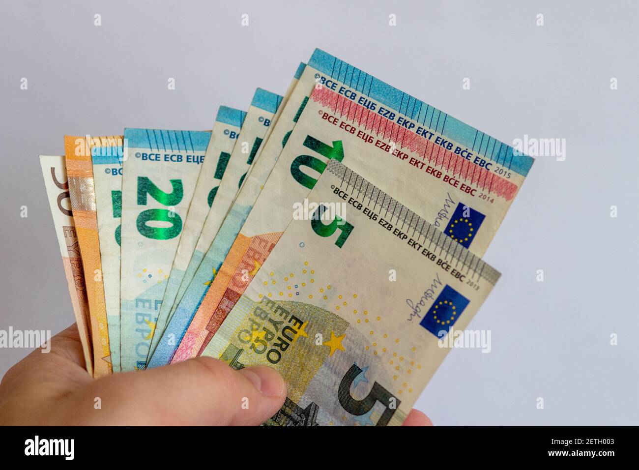 A bundle of euros in the hands on a white background. Euro bills on a ...