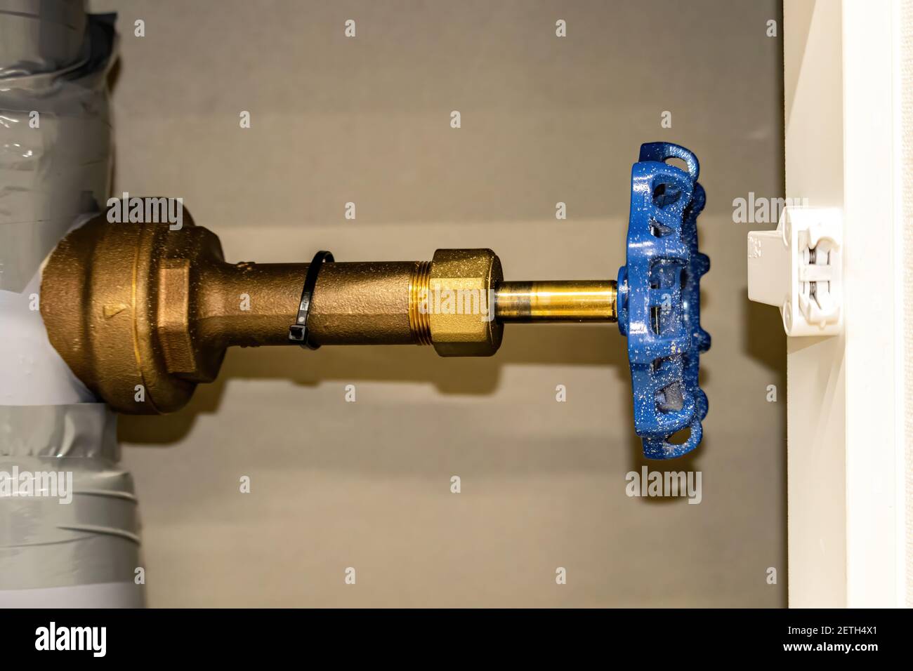 Large, brass metal valve, in blue and brass color, inside a wall Stock ...