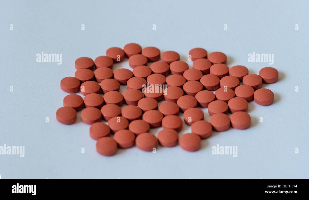 Red tablets on a blue background. Medical tablets Stock Photo - Alamy