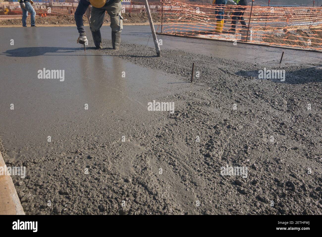 Construction worker levels freshly cast concrete with bull float Stock ...